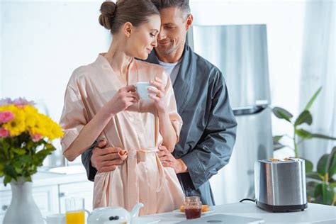 부엌에서 차 한잔과 함께 가운 수용 아름 다운 여 자가 잘생긴 남자 2명에 대한 스톡 사진 및 기타 이미지 2명 남자