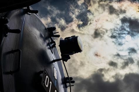 드라마틱한 구름과 숨겨진 태양으로 만들어진 어두운 하늘이 있는 검은 유서 깊은 기관차 의 전면 0명에 대한 스톡 사진 및 기타 이미지 Istock