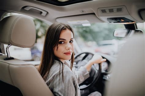 Free Photo Woman In Car Indoor Keeps Wheel Turning Around Smiling