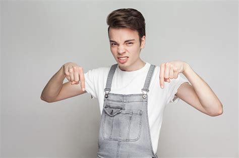 지금 그리고 여기 화가 젊은 갈색 머리 남자 T셔츠와 데님 바지 캐주얼 스타일에 심각한 얼굴로 카메라를 바라보 고 아래로 가리키기에 대한 스톡 사진 및 기타 이미지 Istock