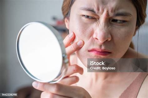아시아 여성은 미니 거울로 얼굴에 여드름과 주름이 생기는 것을 보았을 때 얼굴을 걱정했습니다 35 39세에 대한 스톡 사진 및 기타 이미지 Istock