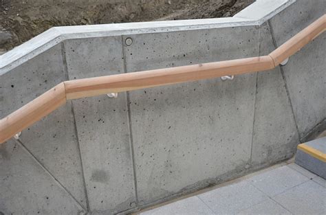 손잡이 의 바닥에서 노란색 빛이있는 오목한 Led 스트립입니다 숨겨진 내장 램프는 남자의 손을 보여줍니다 옹벽이 있는 계단의