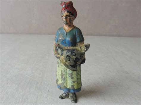 Ancienne figurine fermière tenant poule noire Quiralu Bleu Rouge Vert
