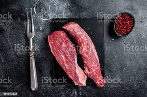 대리석 보드에 생 쇠고기 고기 스테이크 또는 등심 플랩을 바베트하십시오 검은 배경 위쪽 보기 0명에 대한 스톡 사진 및 기타