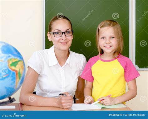 Colegiala De Ayuda Del Profesor Con El Schoolwork En Sala De Clase Imagen De Archivo Imagen De