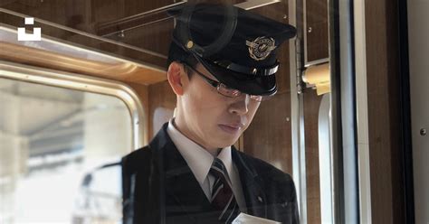 검은 제복을 입은 남자가 종이를 읽는다 흰색 기차 안에 서 있다 사진 Unsplash의 무료 안전 이미지