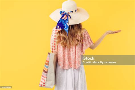 여름 모자를 쓰고 노란 배경에 카메라에 등을 대고 서 있는 여름 젊은 여성 귀여운에 대한 스톡 사진 및 기타 이미지 귀여운 노랑 놀이 Istock