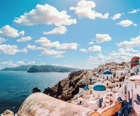 Panoramic View Of Santorinis Whitewashed Houses With Blue Domed