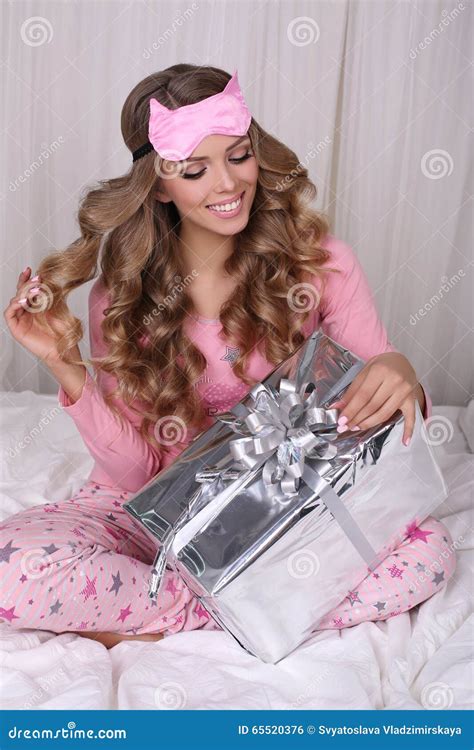 Beautiful Woman With Blond Curly Hair In Pajama With Present Stock