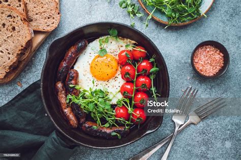 아침 식사 시간 소시지를 곁들인 달걀 튀김 블랙 아이언 팬의 체리 토마토 마이크로 그린을 제공 합니다 평면도 평 신도 0명에