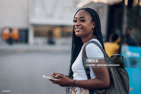 스마트 폰을 사용하고 버스 앞에 서있는 아프리카 계 미국인 여성 20 24세에 대한 스톡 사진 및 기타 이미지 20 24세 25 29세 Brand Name Smart