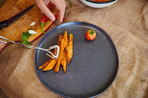 톱 뷰 요리사가 접시를 제공하고 해군 세라믹 플레이트에 고구마 튀김을 넣습니다 광고 공간을 복사하십시오 웹 배너 메뉴 감자