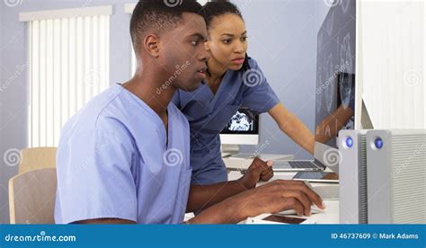 African American Medical Specialists Working Together On Computer Stock
