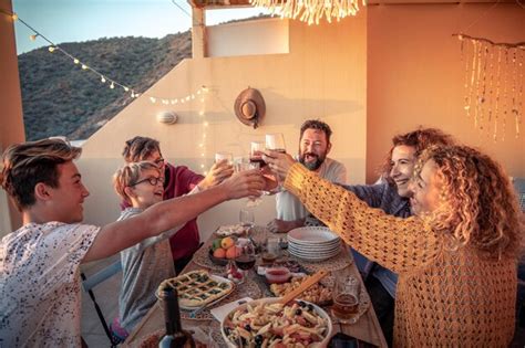 Premium Photo Friends Toasting Drinks At Table During Sunset