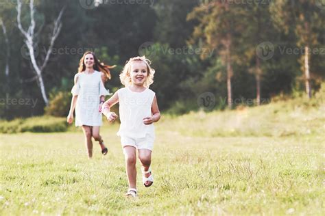 maman et petite fille se promènent dehors sur le terrain et les bois en