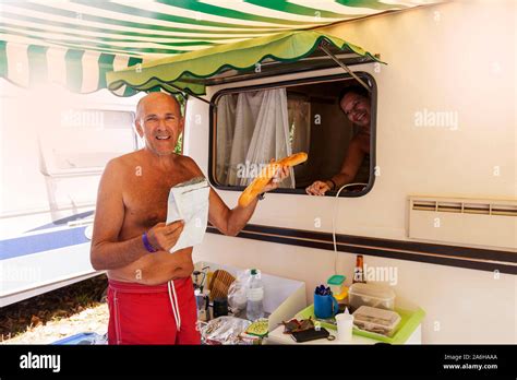Smiling Mature Man Preparing Lunch With His Wife In The Striped Tent Of