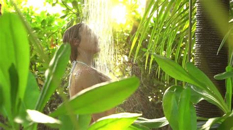 A Woman Showering Outdoors Surrounded By Lush Tropical Greenery Stock Video Video Of