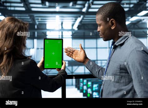 system administrators in data center use green screen tablet to