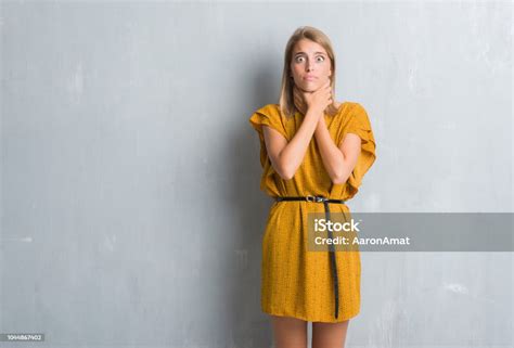 아름 다운 젊은 여 서 그런 지 회색 드레스 소리를 입고 벽과 질 식 때문에 고통 스러운 목을 건강 문제입니다 질 식 자살 개념