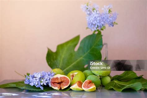 ベージュの背景に青い花が咲く葉とガラスの花瓶を持つイチジクの収穫 みずみずしいのストックフォトや画像を多数ご用意 みずみずしい