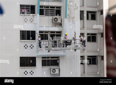 Three Workers On The Scaffolded Elevators In Height Working Their Best