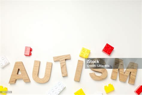 레고가 있는 밝은 배경에 나무 글자로 된 자폐증이라는 단어 텍스트 장소 세계 자폐증의 날 개념 0명에 대한 스톡 사진 및 기타