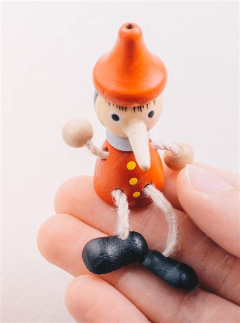 Premium Photo Wooden Pinocchio Doll In Hand On A White Background