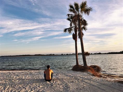Premium Photo Rear View Of Shirtless Man Sitting At Beach