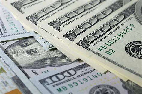a stack of hundred dollar bills arranged in a fan shape depicting a