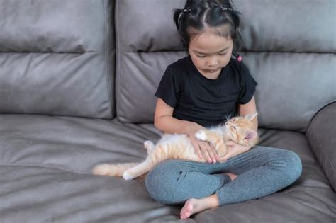 그녀의 귀여운 고양이와 함께 아시아 소녀 그녀는 새끼 고양이와 함께 노는 프리미엄 사진