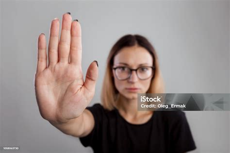 아름 다운 젊은 여 자가 입고 Blak 셔츠와 큰 안경 중지 하 고 손의 종 려를 가진 노래 얼굴에 부정적이 고 심각한 제스처와 경고 식입니다 가냘픈에 대한 스톡 사진 및