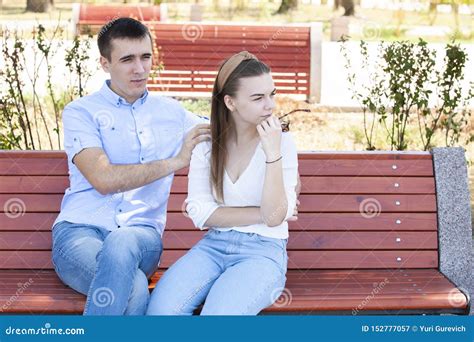 Pares Jovenes Felices En El Amor Que Se Sienta En Un Banco De Parque Imagen De Archivo Imagen