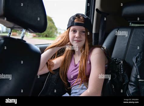 Tween Girl With Red Hair And Backwards Baseball Hat In Car Stock Photo