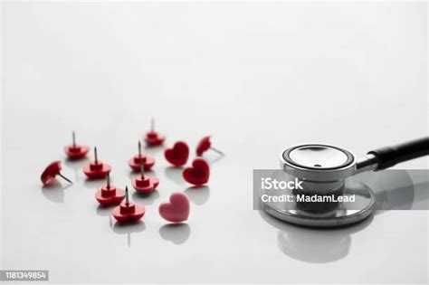 병원 및 클리닉 흰색 배경에 대한 작은 분홍색과 빨간색 날카로운 핀 심장 모양과 건강 의료 심장 의사 진단을위한 금속 청진기