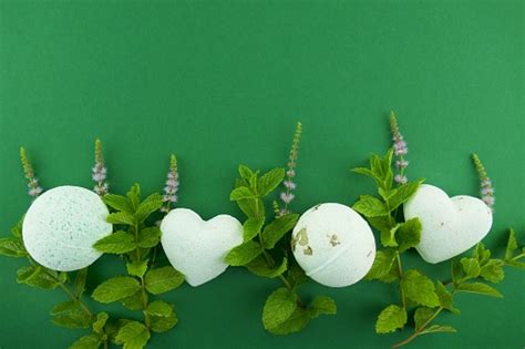 민트와 박하 목욕 Bombsorganic 바디 화장품 추출합니다 목욕 폭탄 라운드 하 고 민트 추출 및 밝은 녹색 배경에 신선한 민트의 잔 가지와 심장 모양 0명에 대한