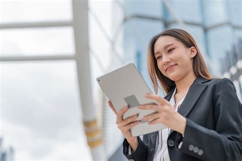 매력적인 젊은 아시아 전문 사업가 숙녀 그녀의 얼굴에 좋은 미소를 가진 그녀의 얼굴에 마케팅 및 판매 재고 보고서의 최신 업데이 트를보고 방콕 도시의 중앙 비즈니스 지구에