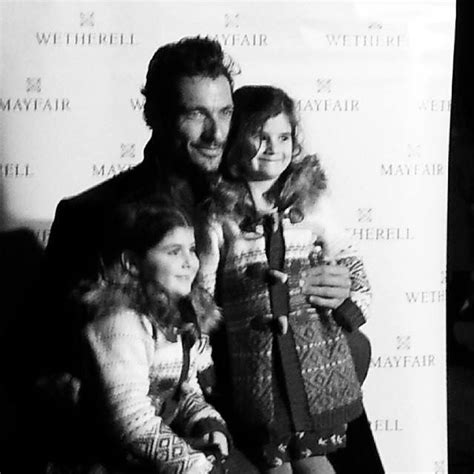 A Black And White Photo Of A Man With Two Girls In Front Of A Wall
