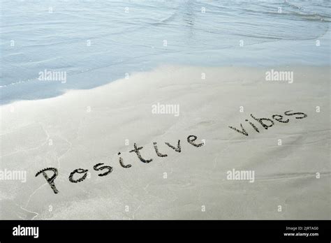 Concept Or Conceptual Positive Vibes Text Handwritten In Sand On A