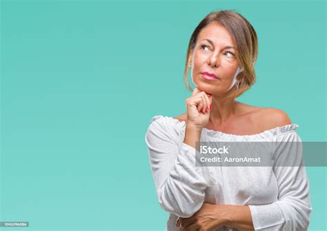 중 년 손으로 턱 질문 잠겨있는 표현에 대 한 생각에 고립 된 배경 위에 수석 히스패닉 여자 사려깊은 얼굴 미소 의심 개념입니다