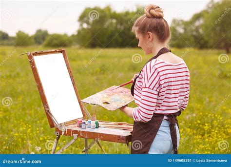 Изображение женского художника работая с картиной акварели представляя в под открытым небом
