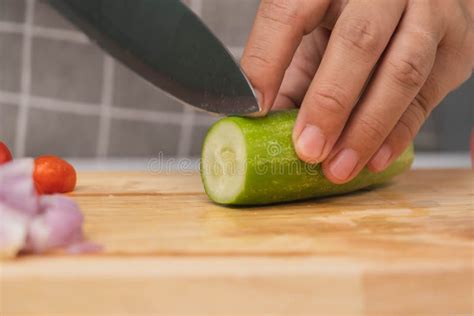 Female Hand Using A Knife To Slice Cucumbers On A Cutting Board Close Up Woman With Kitchen