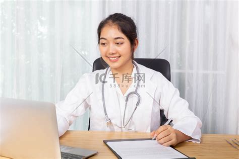 女医生坐在办公室的办公桌上专注于她的工作高清摄影大图 千库网