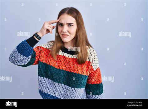 Young Hispanic Girl Standing Over Blue Background Pointing Unhappy To