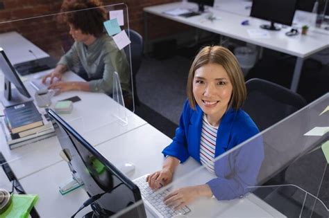 Premium Photo Diverse Male And Female Colleagues Sitting In Front Of Computers Separated By