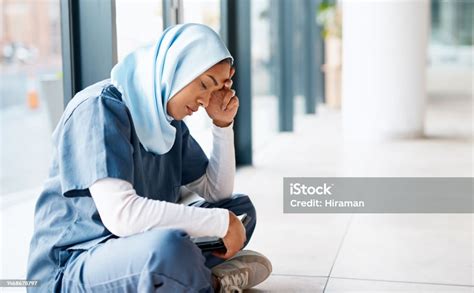 우울증 소진 및 정신 건강으로 병원에서 간호사와 함께 슬프고 스트레스와 의료 의료 불안 및 의학은 두통 생각 및 피곤한 클리닉 바닥에 무슬림 여성과 함께 간호사에 대한 스톡