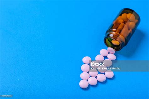 분홍색 정제는 파란색 배경에 화살표의 형태로 유리 거품에서 따라 진다 0명에 대한 스톡 사진 및 기타 이미지 0명 건강