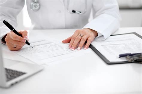 Premium Photo Closeup Of A Female Doctor Filling Out Application Form
