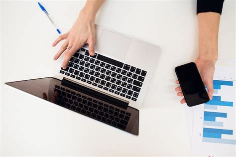 Premium Photo Laptop With Women Hand And Paper Graph On White Table