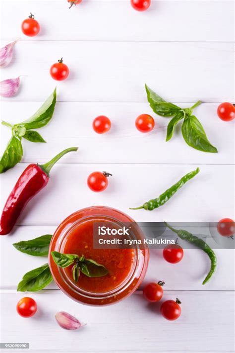 흰색 바탕에 유리 항아리에 허브 마늘 및 레드 핫 칠리 페퍼스 체리 토마토 토마토 케첩 소스 수 제 토마토 소스와 신선한 토마토입니다 평면 위치 최고 보기 건강한 식생활에