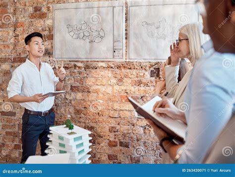 Group Of Diverse Architects Discussing Plans Blueprints And Schematics During A Meeting In